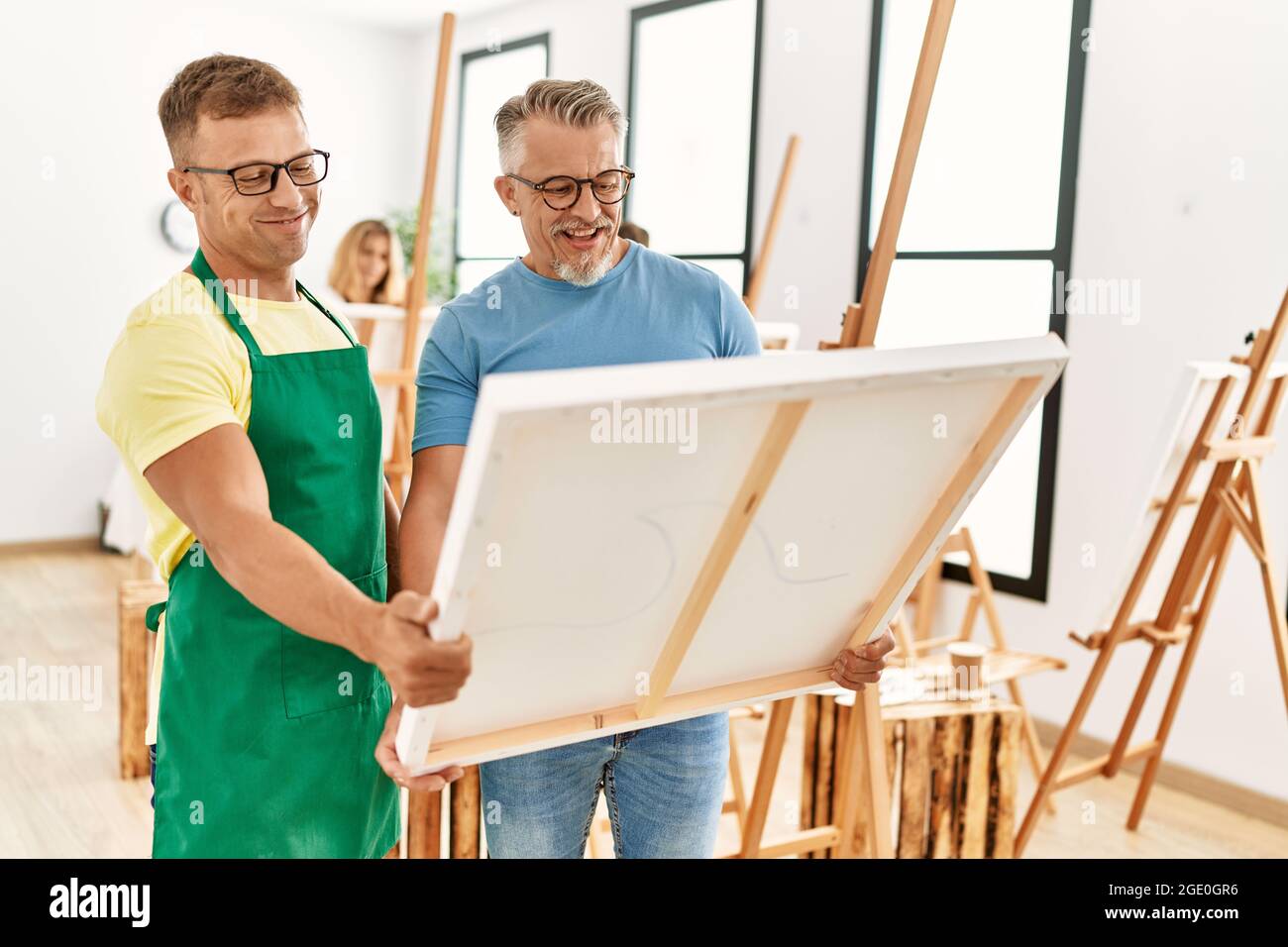 Group of middle age people drawing at art studio. Two students smiling ...