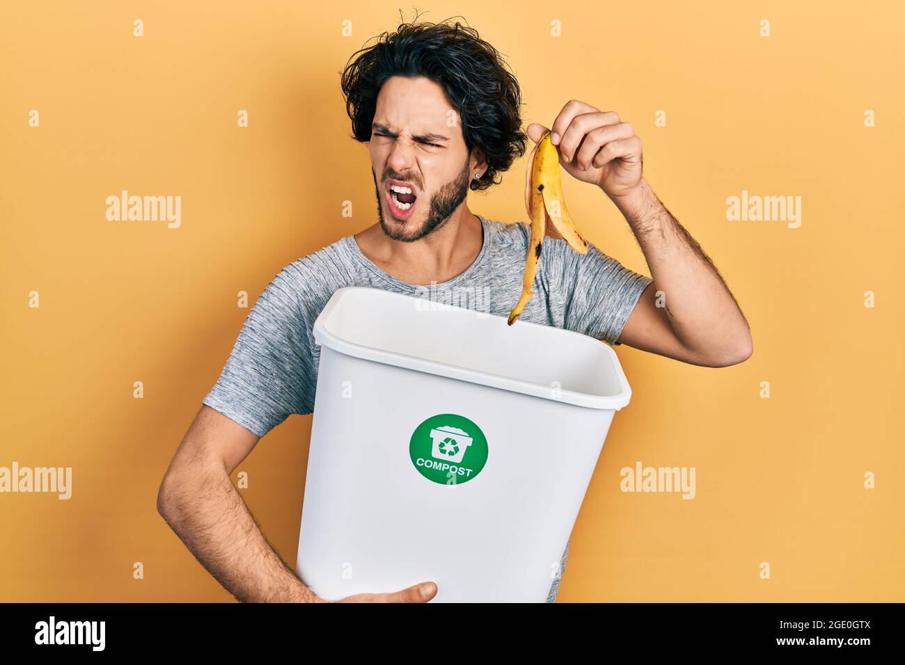 Handsome hispanic man recycling banana peel composting organic ...