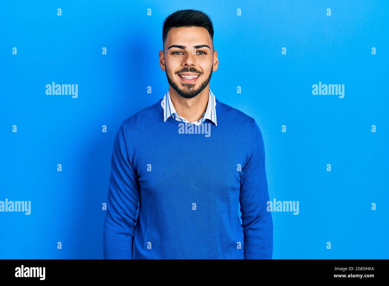 Young hispanic man with beard wearing casual blue sweater with a happy ...
