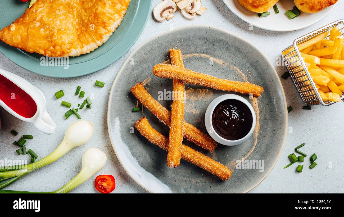A top view of a plate of fresh churros served with chocolate sauce ...
