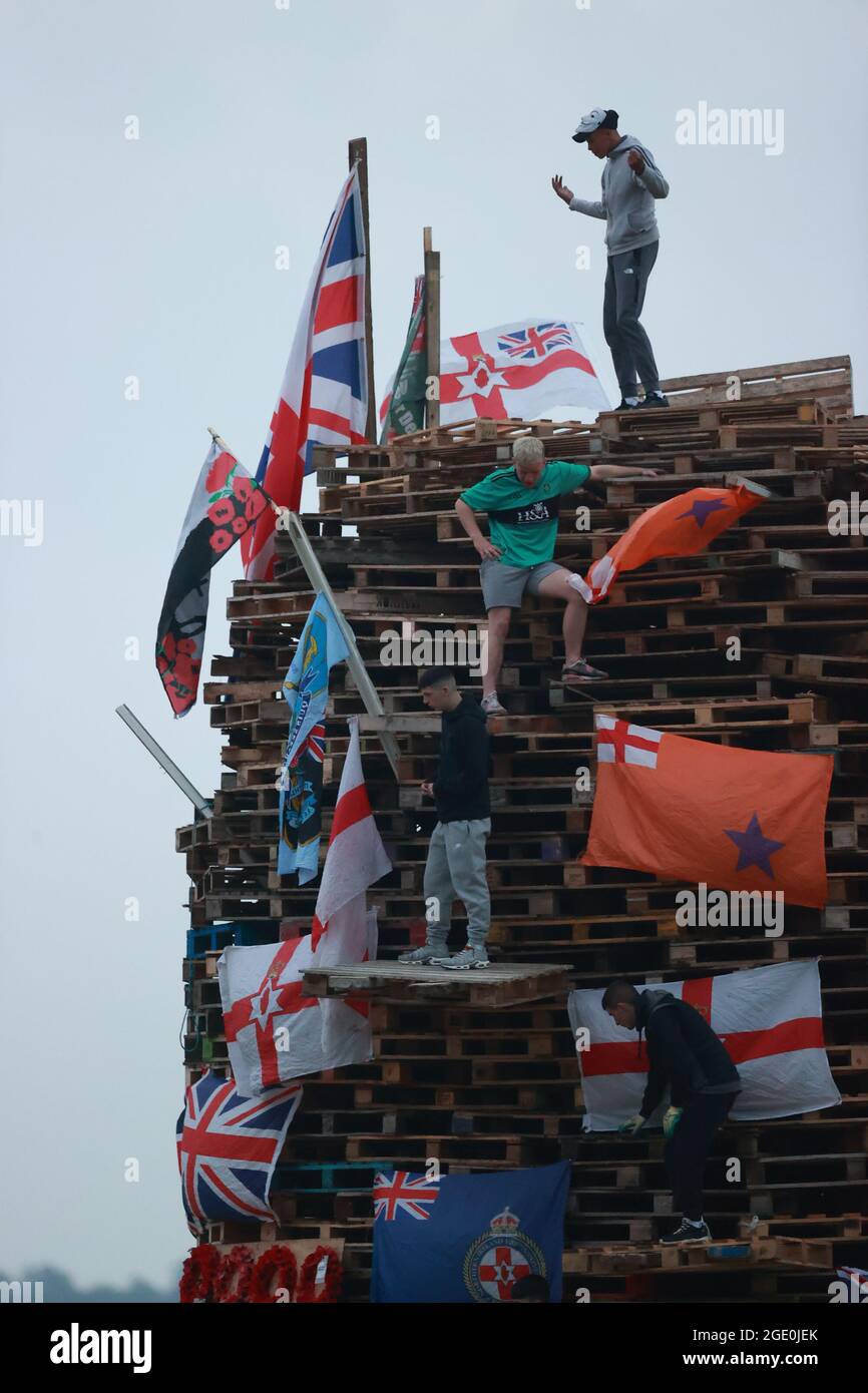 Flags and banners are hung on a large bonfire being built to mark the ...
