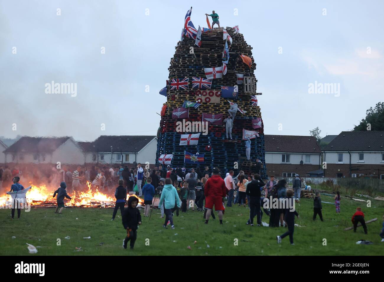 Flags and banners are hung on a large bonfire being built to mark the ...