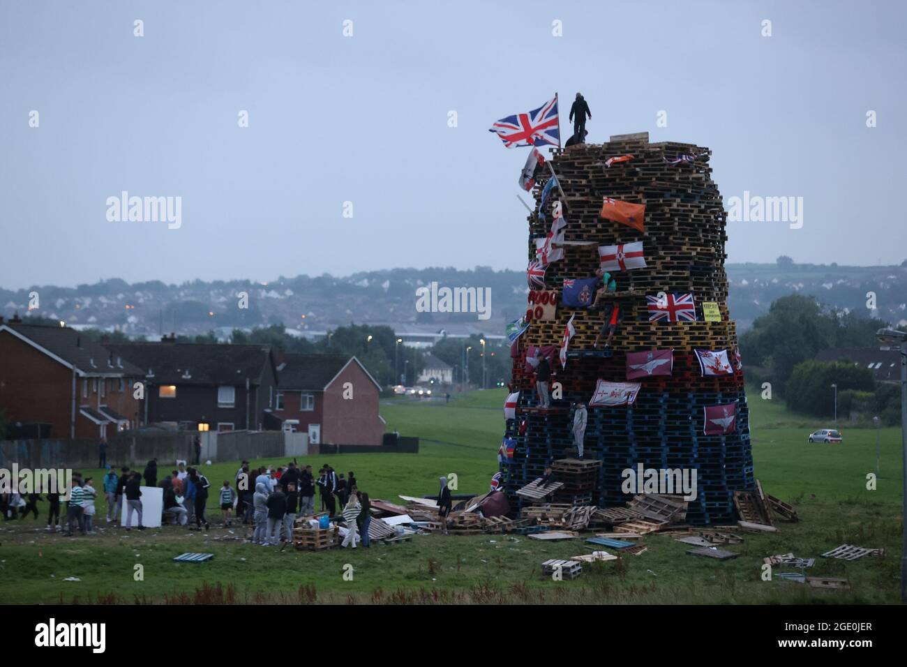 Flags and banners are hung on a large bonfire being built to mark the ...