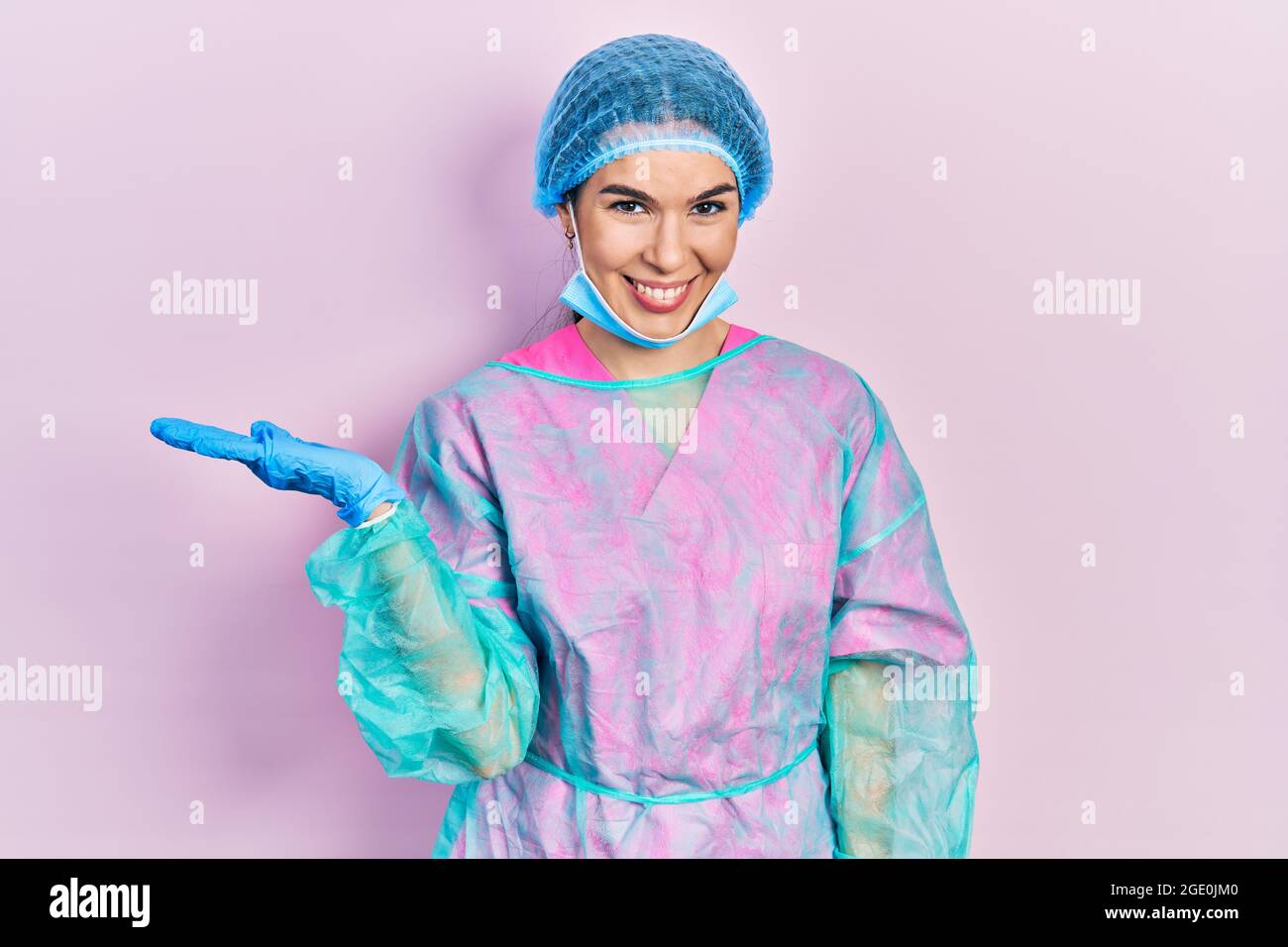 Young brunette woman wearing surgeon uniform and medical mask smiling ...