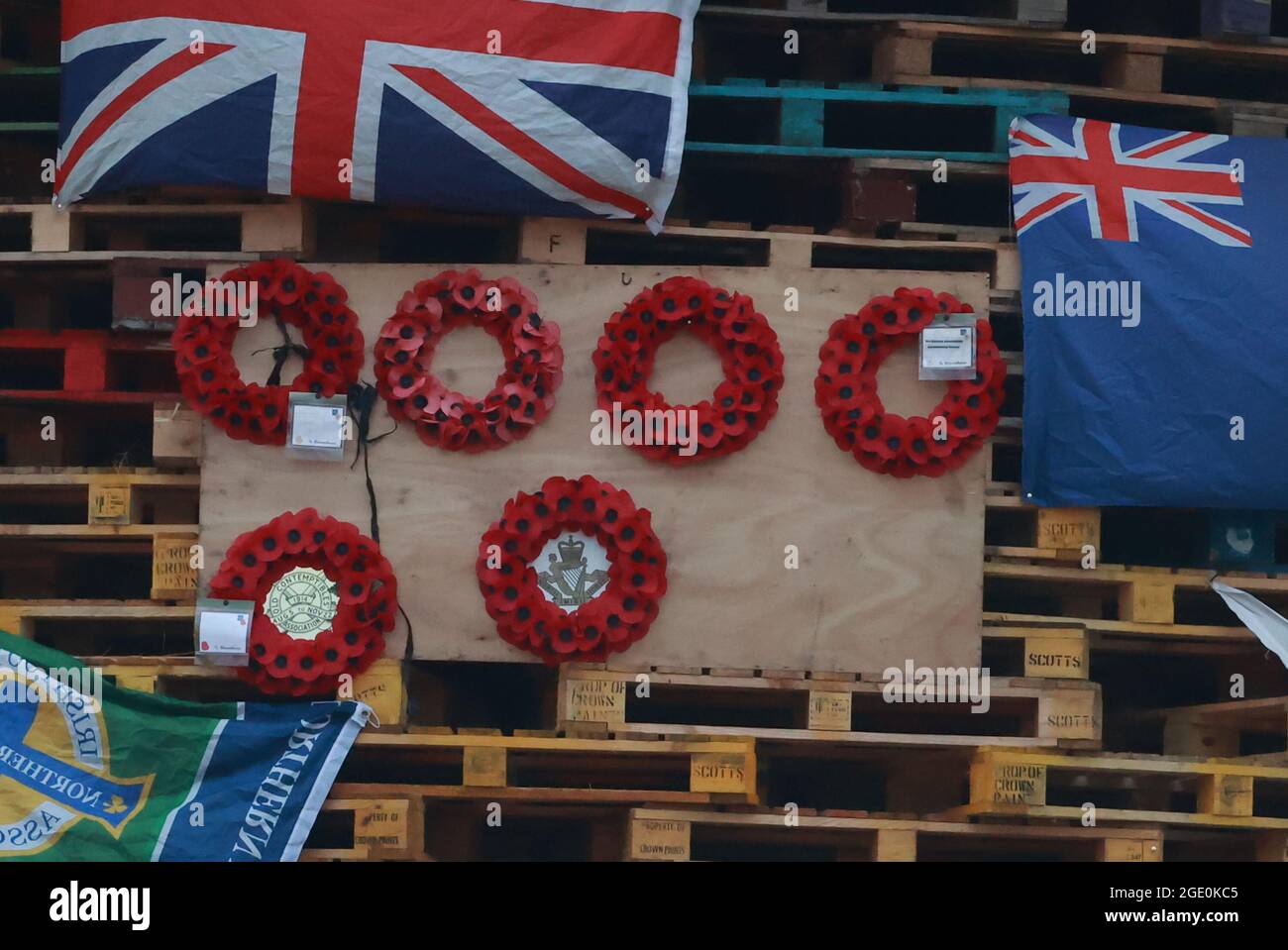 Poppy wreaths are hung on a large bonfire being built to mark the ...