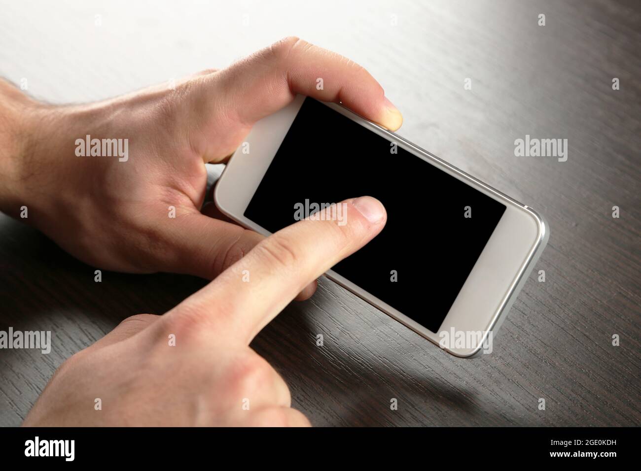 Hands holding smart mobile phone on wooden table background Stock Photo ...