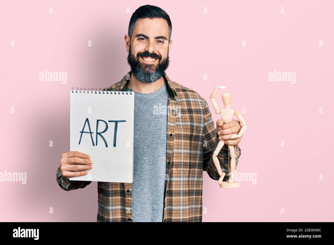 Hispanic man with beard holding art notebook and manikin smiling with a ...