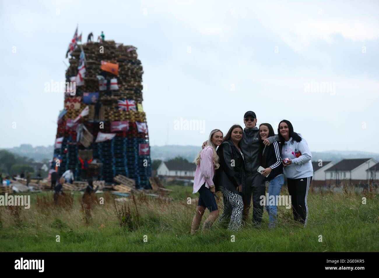 Locals pose for a photograph in front of a large bonfire ready to be ...