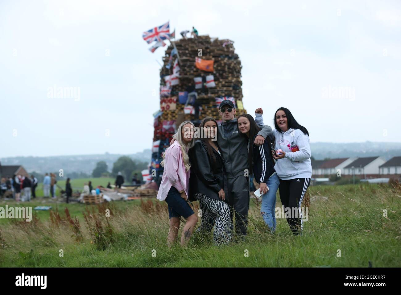 Locals pose for a photograph in front of a large bonfire ready to be ...
