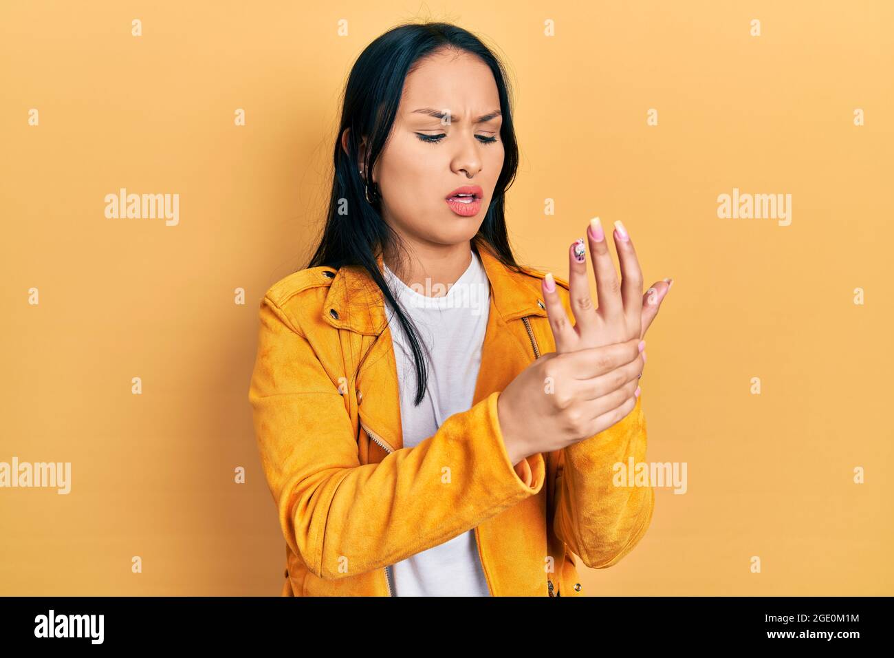 Beautiful hispanic woman with nose piercing wearing yellow leather ...