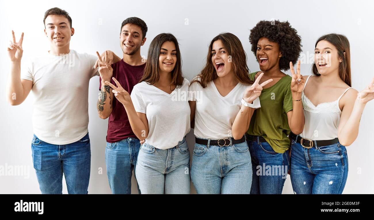 Group of young friends standing together over isolated background ...
