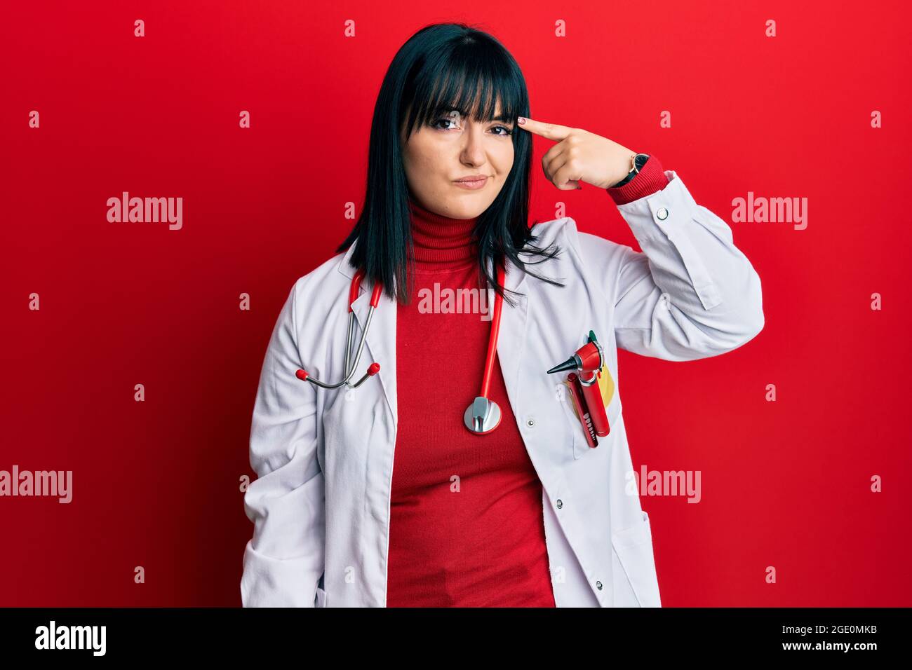 Young hispanic woman wearing doctor uniform and stethoscope pointing ...
