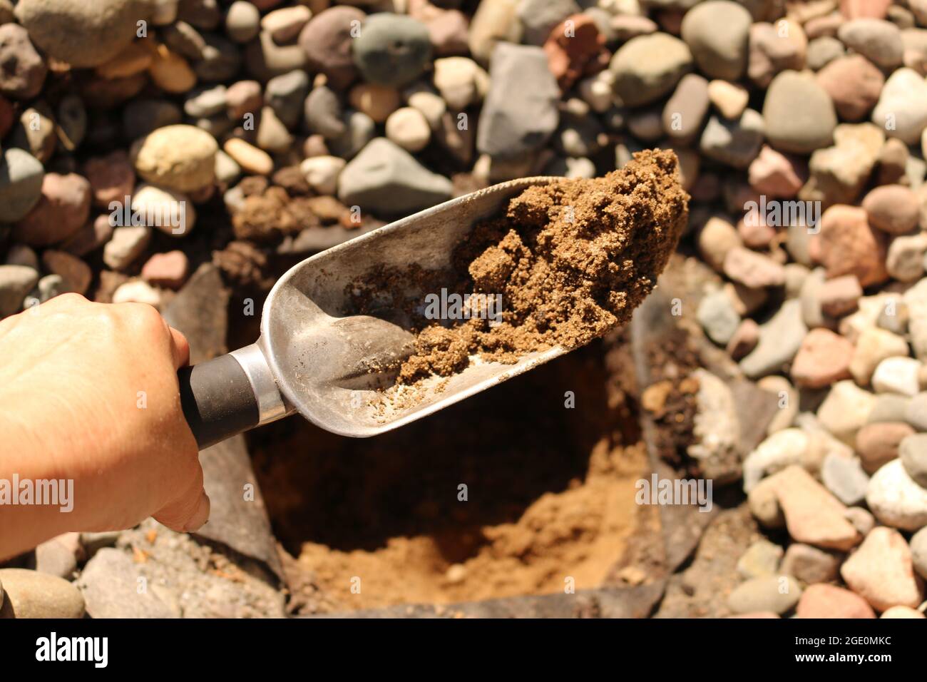 Using a garden trowel to dig a hole Stock Photo - Alamy