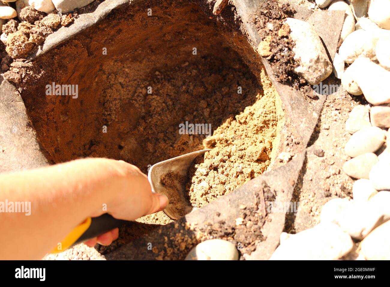 Using a garden trowel to dig a hole Stock Photo - Alamy