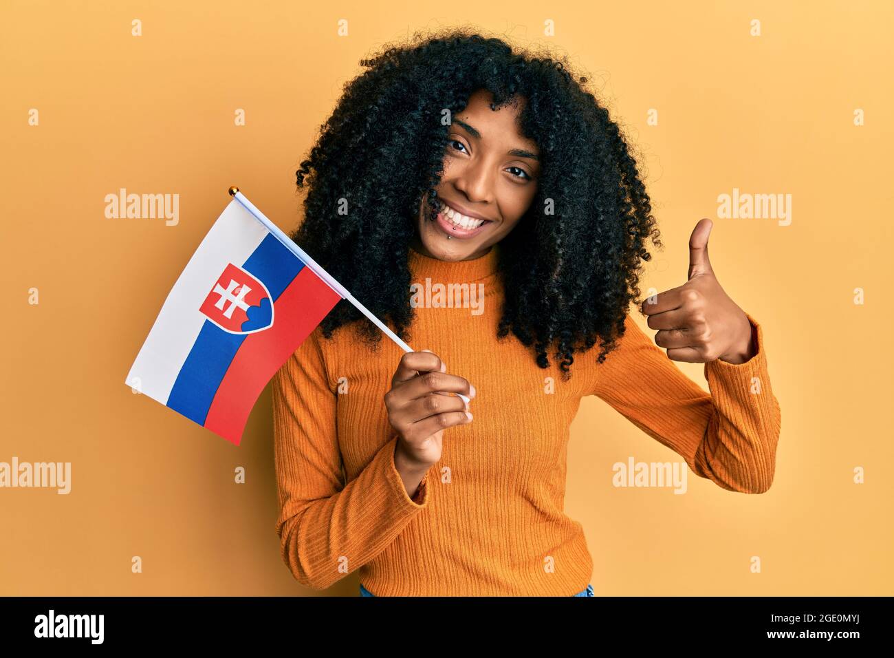 African american woman with afro hair holding slovakia flag smiling ...