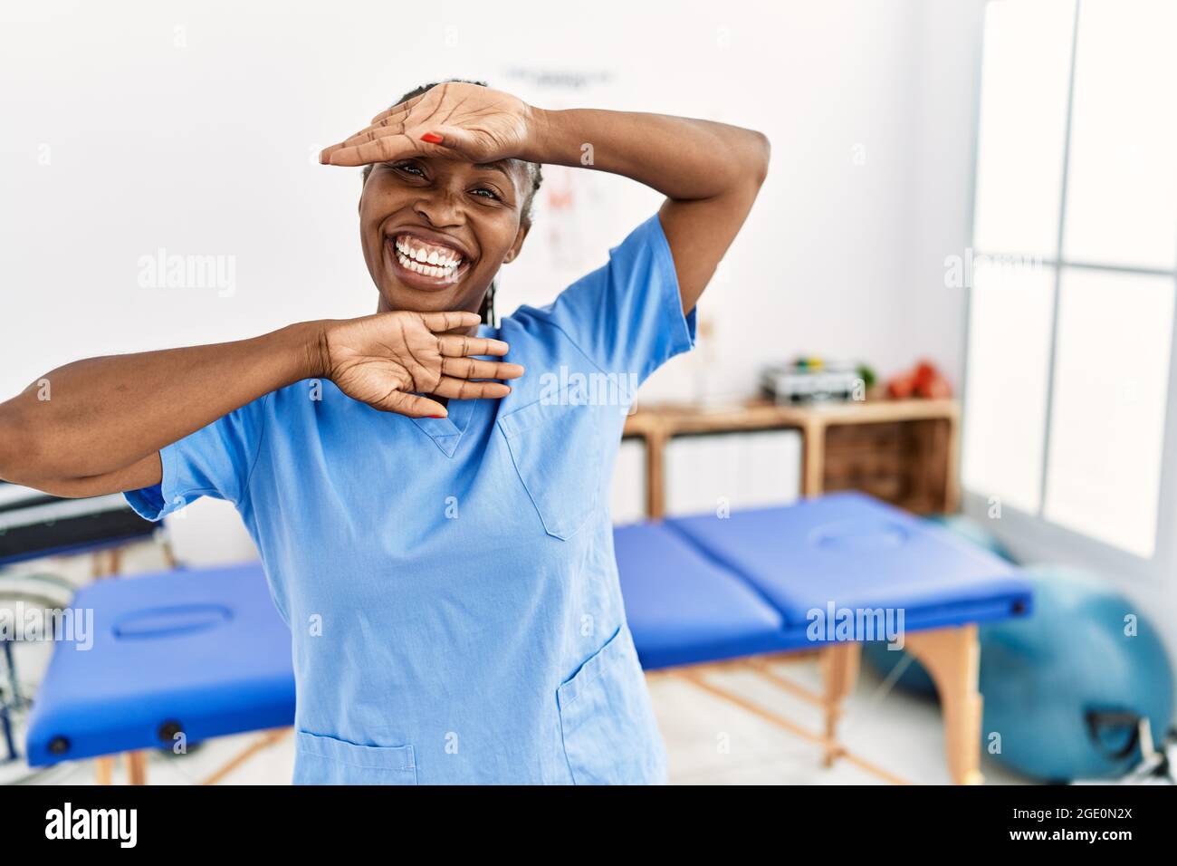 Black woman with braids working at pain recovery clinic smiling ...