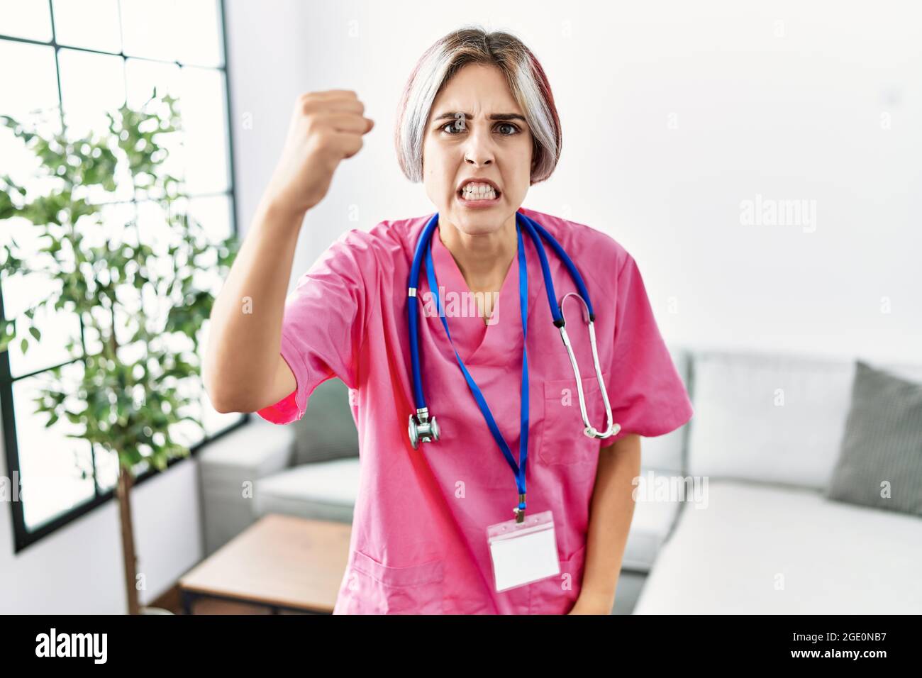 Young beautiful woman wearing doctor uniform and stethoscope angry and ...