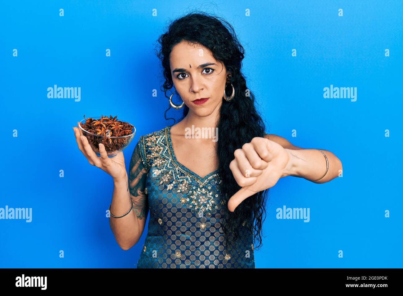 Young woman wearing bindi and traditional kurta dress holding bowl of ...