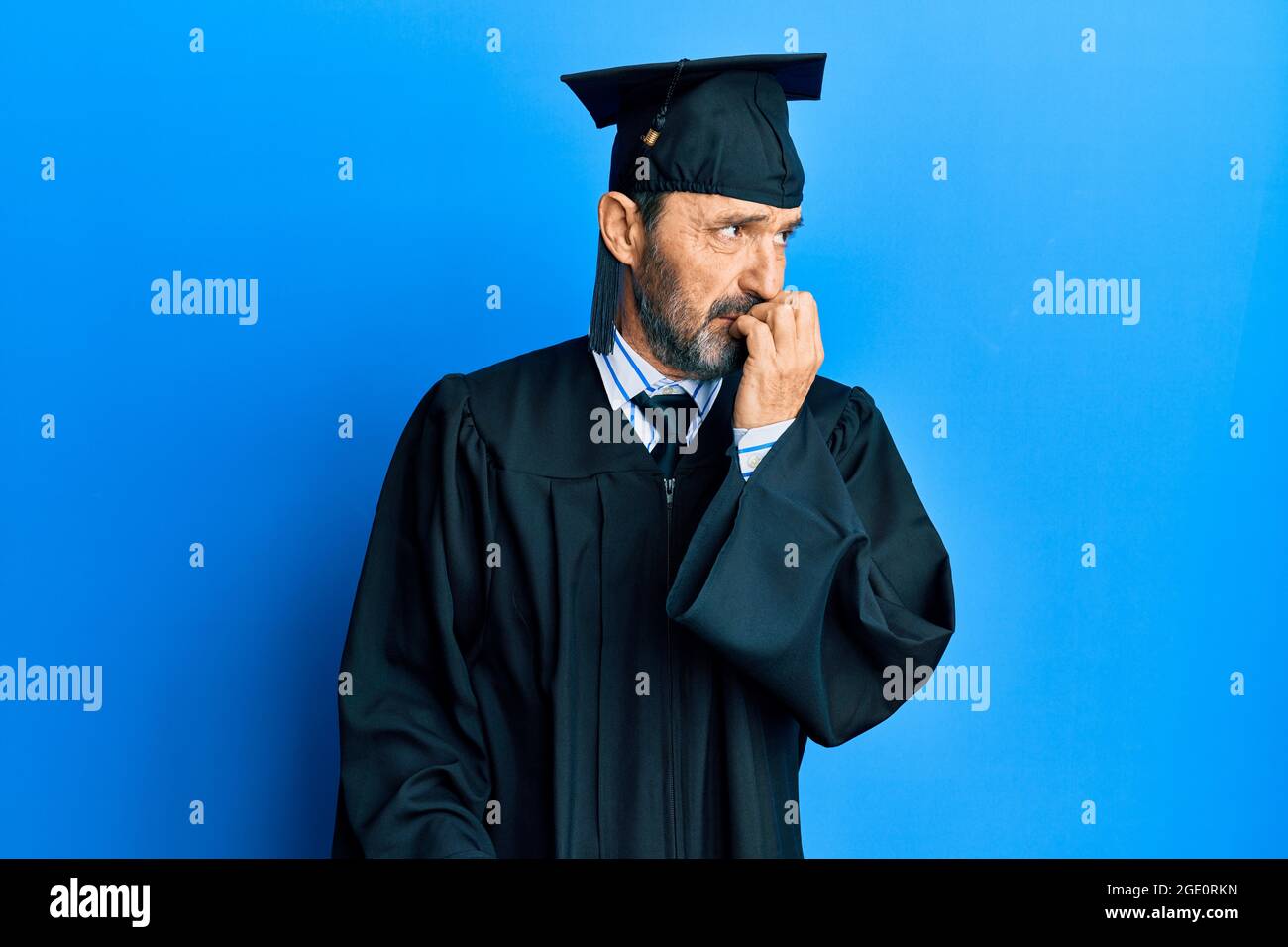 Middle age hispanic man wearing graduation cap and ceremony robe ...