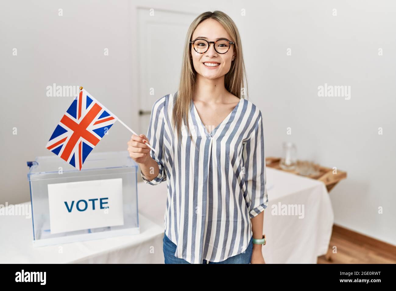 Asian young woman at political campaign election holding uk flag ...