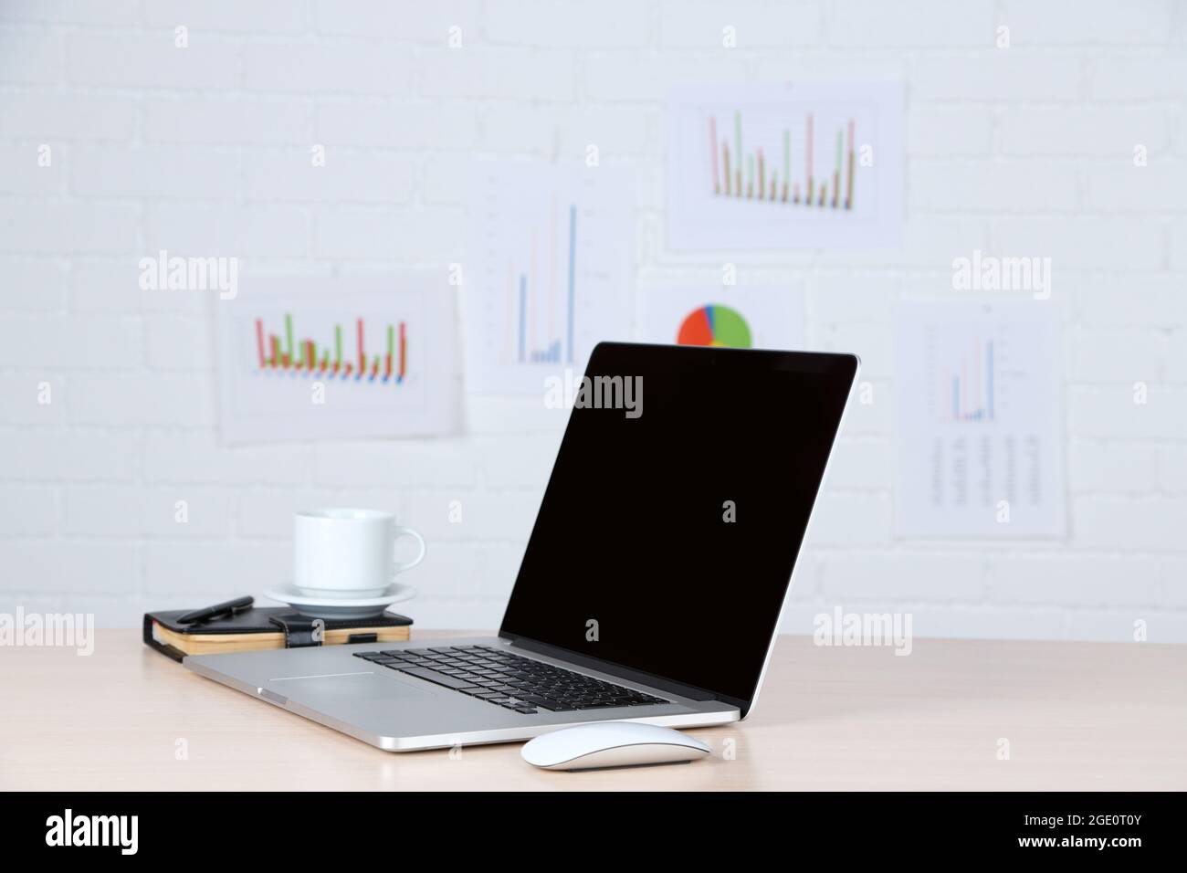 Modern laptop on table, on white wall background Stock Photo - Alamy
