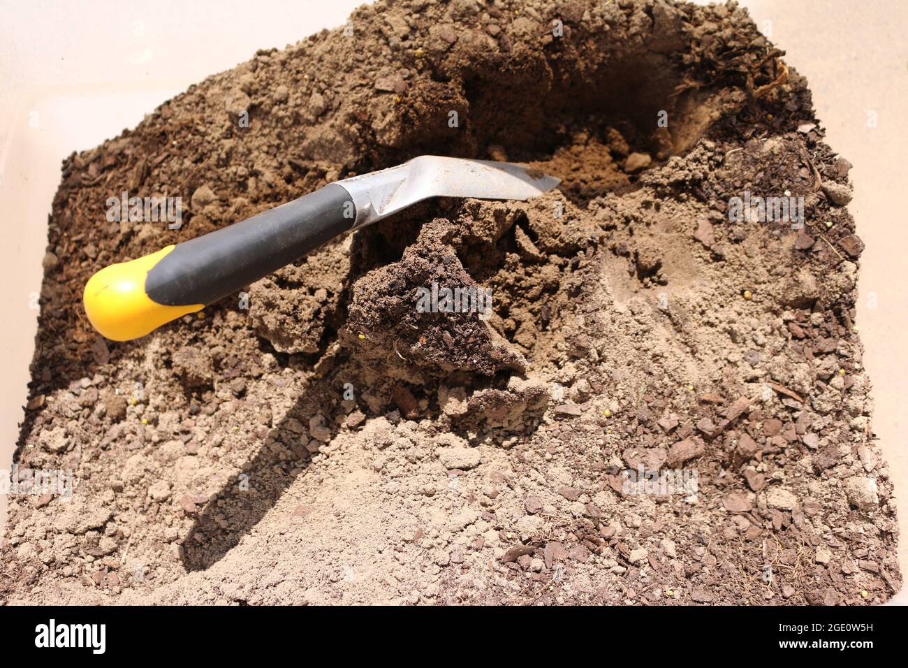Trowel in a container of dirt Stock Photo - Alamy