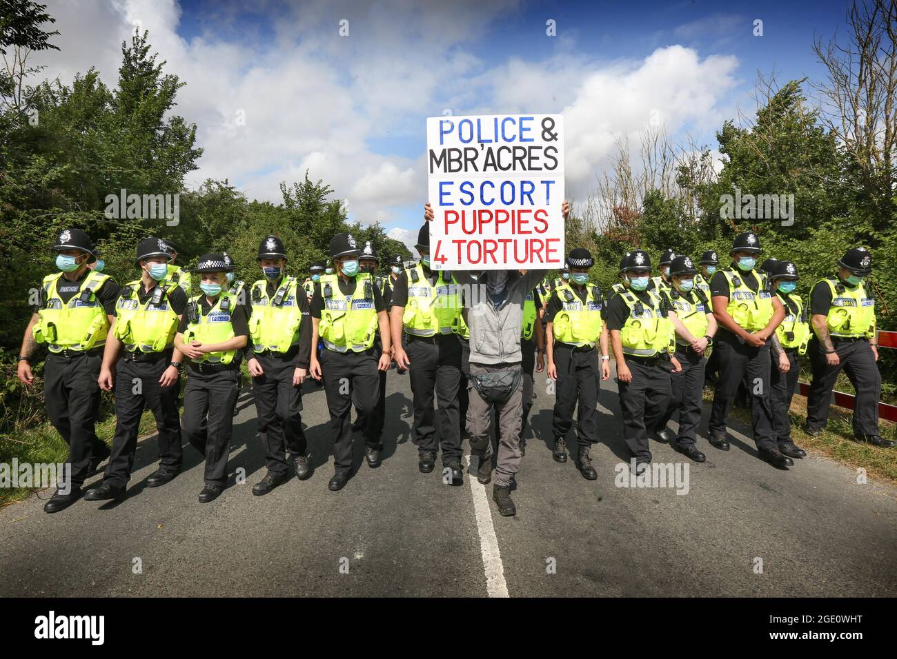 Huntingdon, UK. 15th Aug, 2021. A protester walks ahead of officers ...