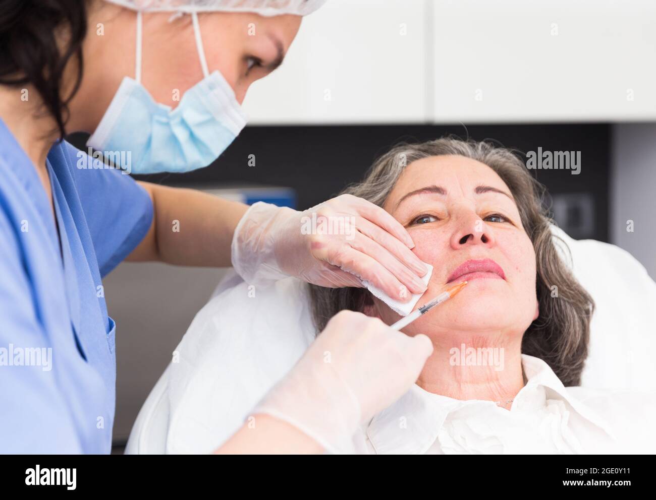 Aged woman getting injections for face skin tightening Stock Photo - Alamy