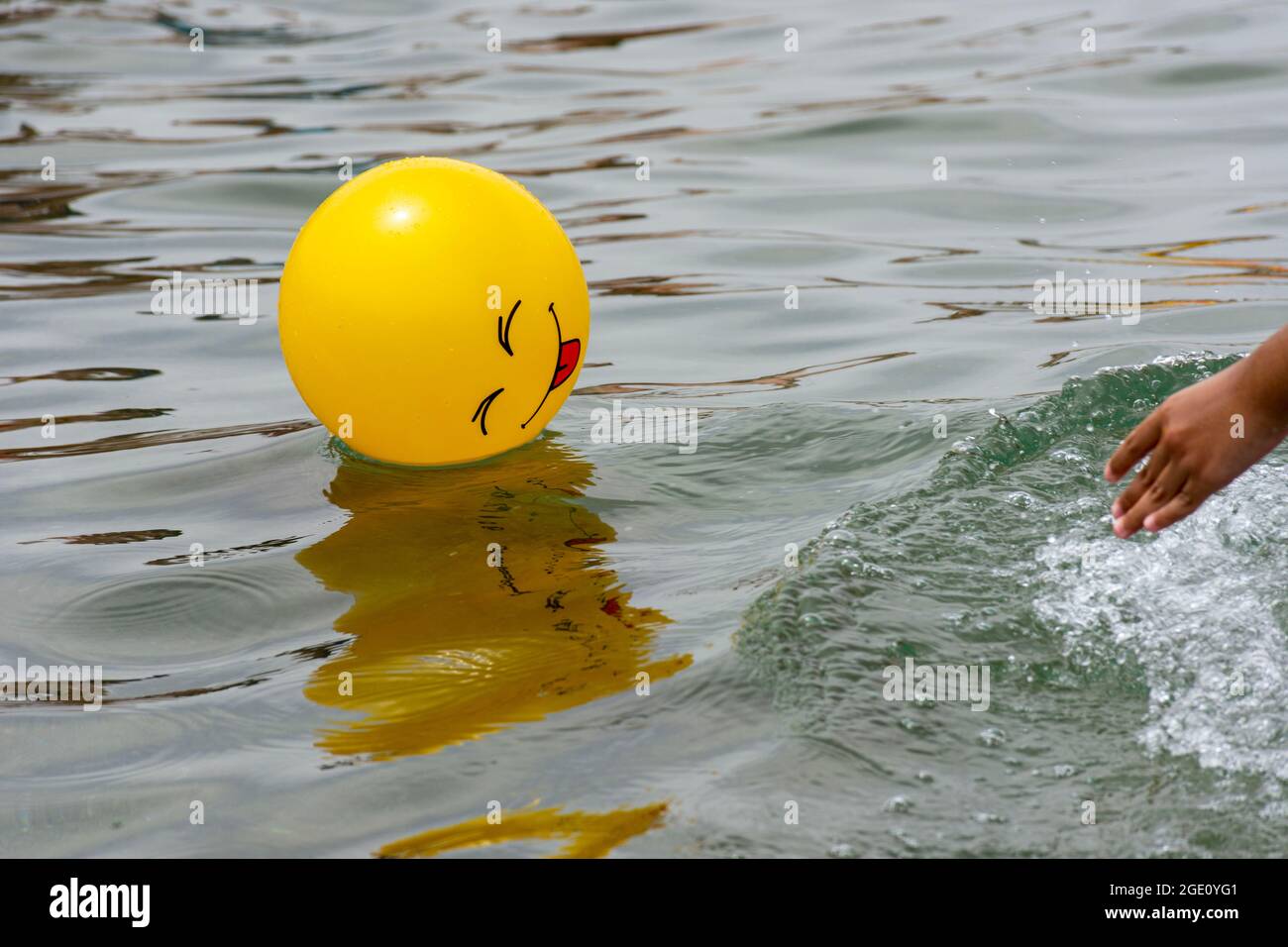 Close up of yellow beach ball floating on the water, smile face Stock ...