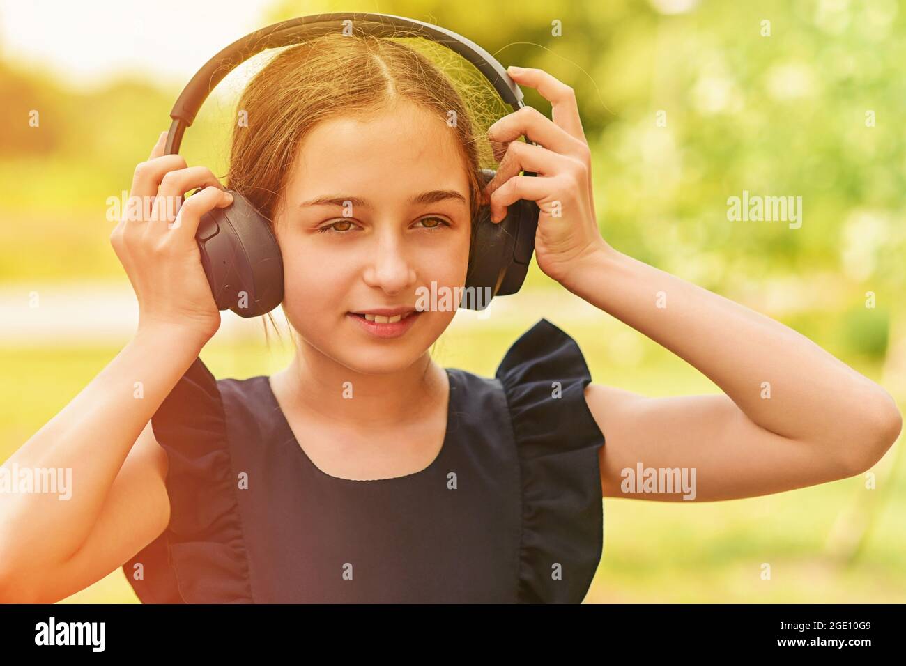 Happy little girl wearing headphones. Stereo sound Stock Photo - Alamy