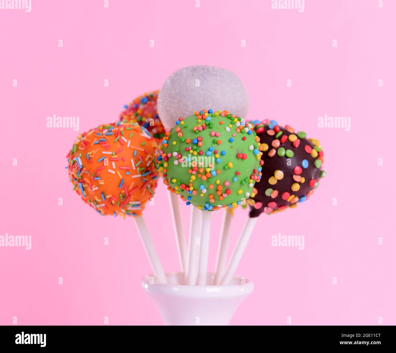 Sweet cake pops in vase on pink background Stock Photo - Alamy