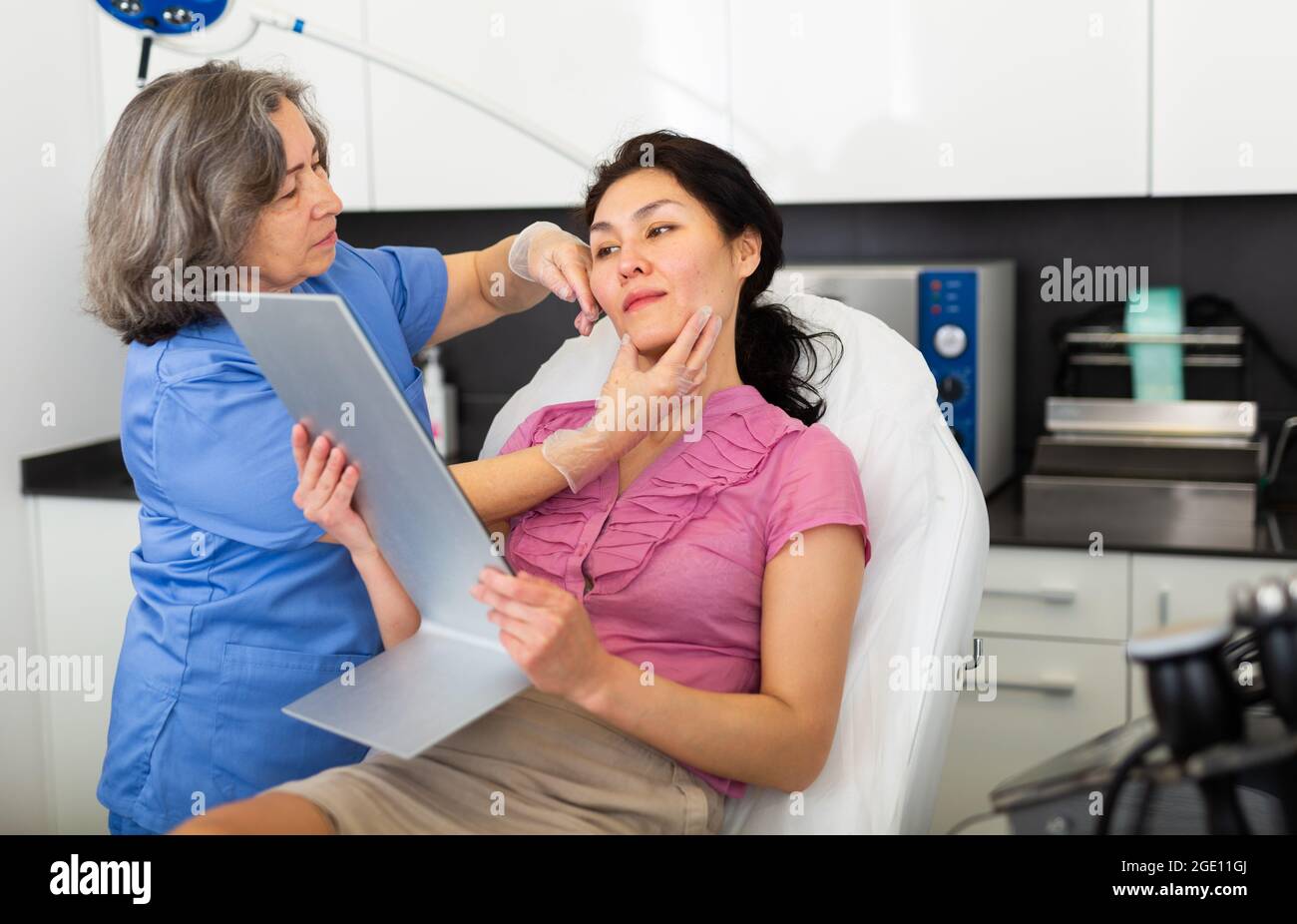Cosmetician explaining future treatment to female patient Stock Photo ...