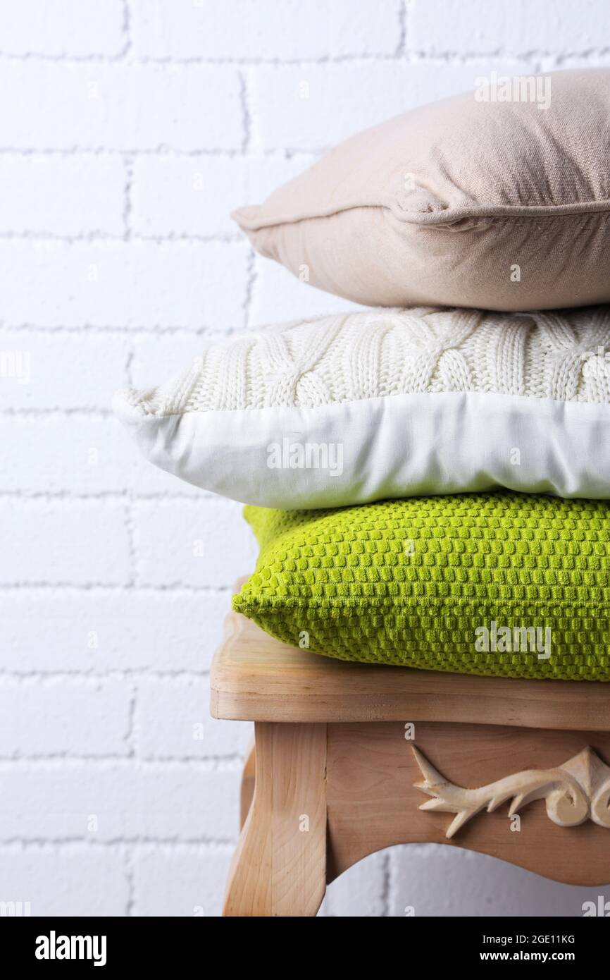 Pillows on small wooden table and white brick wall background Stock ...
