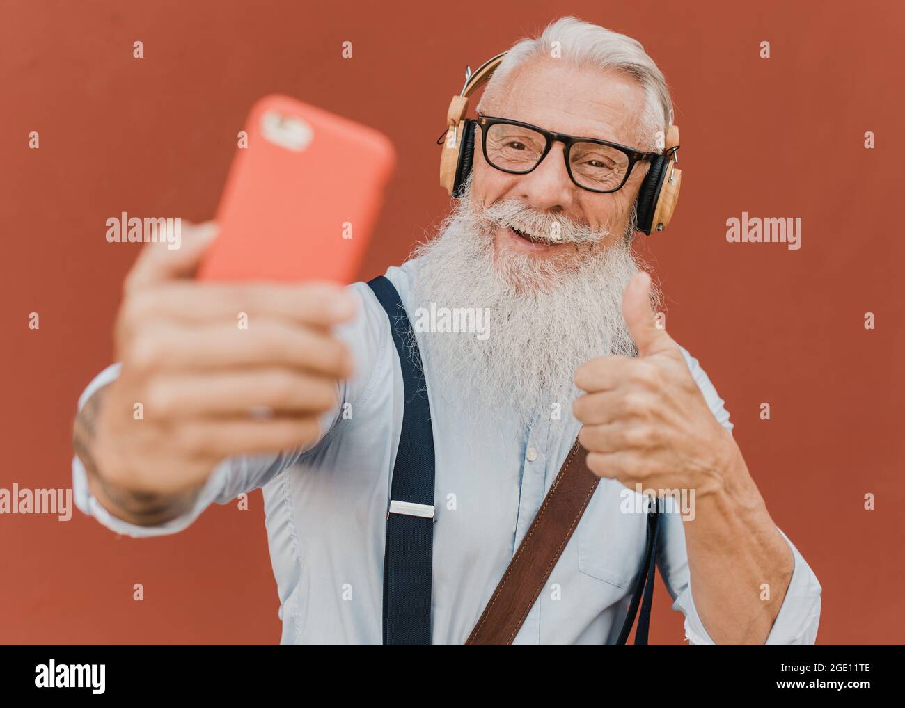 older man makes video call with his smartphone while indicating that it ...