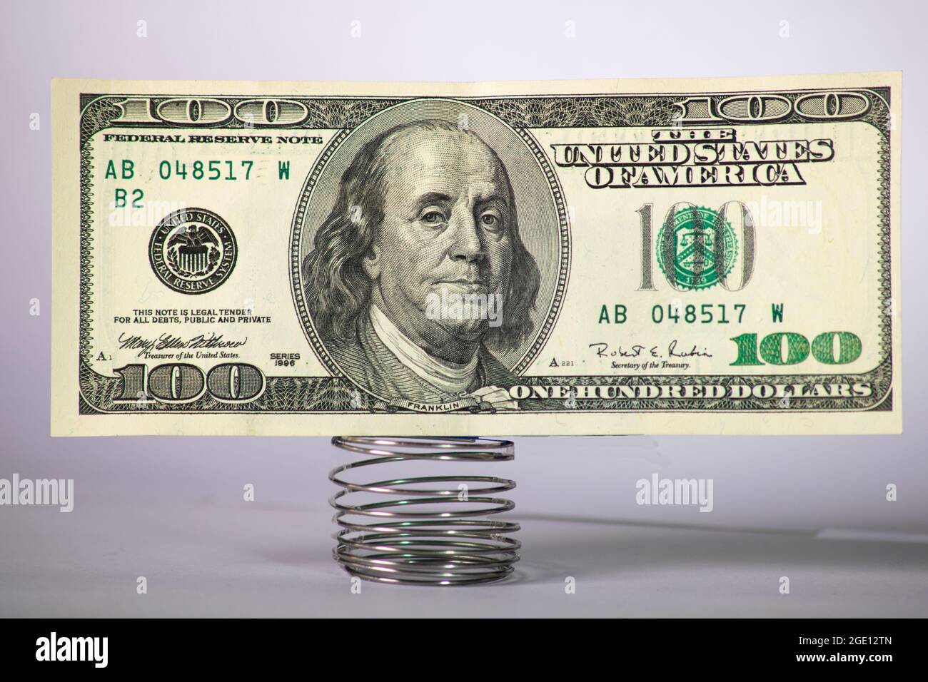 Dollar bill on a spring about to come loose Stock Photo - Alamy