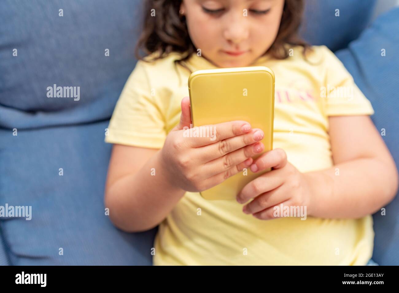 Portrait of little girl at home using the mobile phone Stock Photo - Alamy
