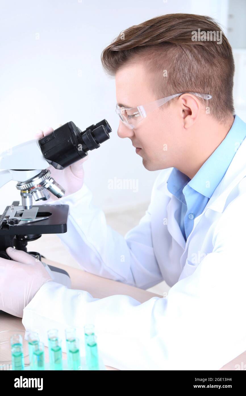 Male scientist using microscope in laboratory Stock Photo - Alamy