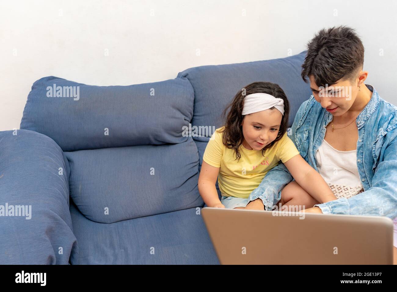 Mother and daughter in the sofa using the computer Stock Photo - Alamy