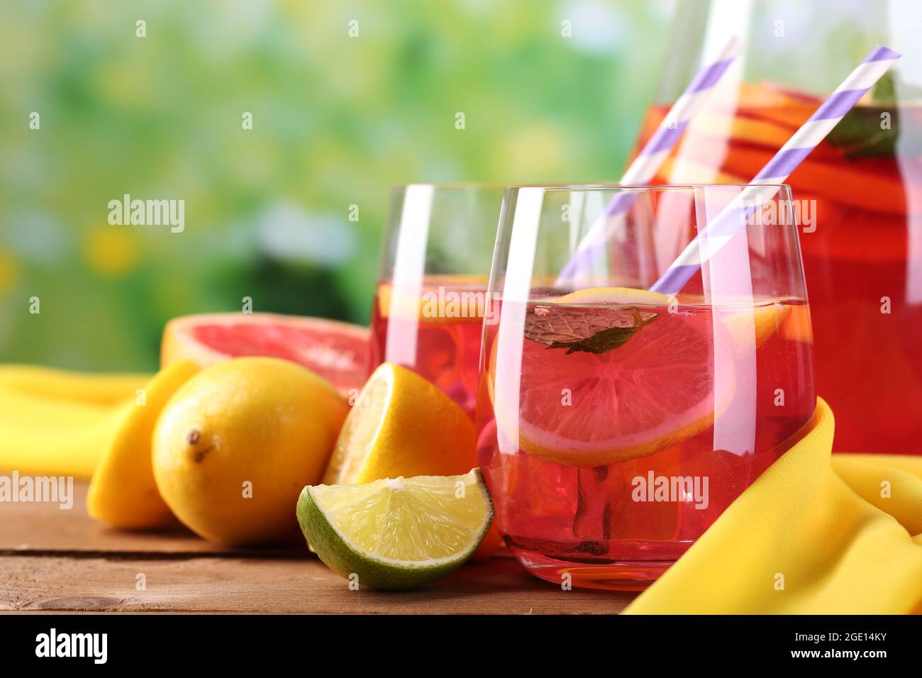 Pink lemonade in glasses and pitcher on table on natural background ...