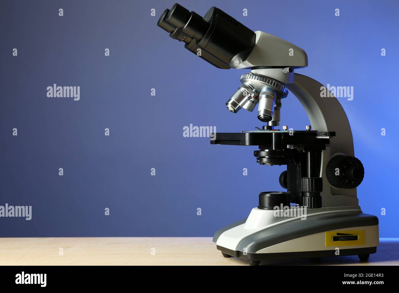 Microscope on table, on color background Stock Photo - Alamy