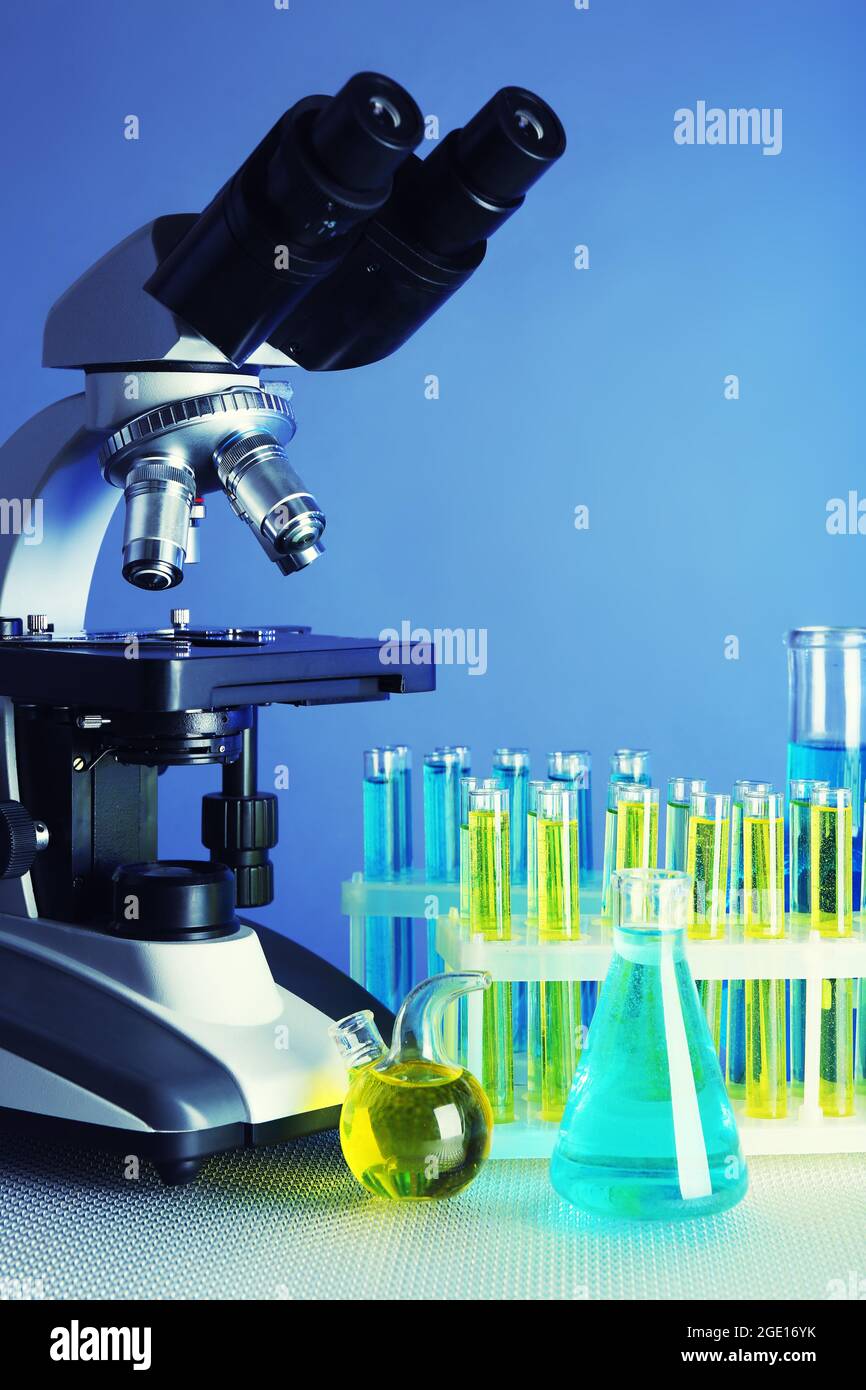 Microscope and test tubes on table, on color background Stock Photo - Alamy