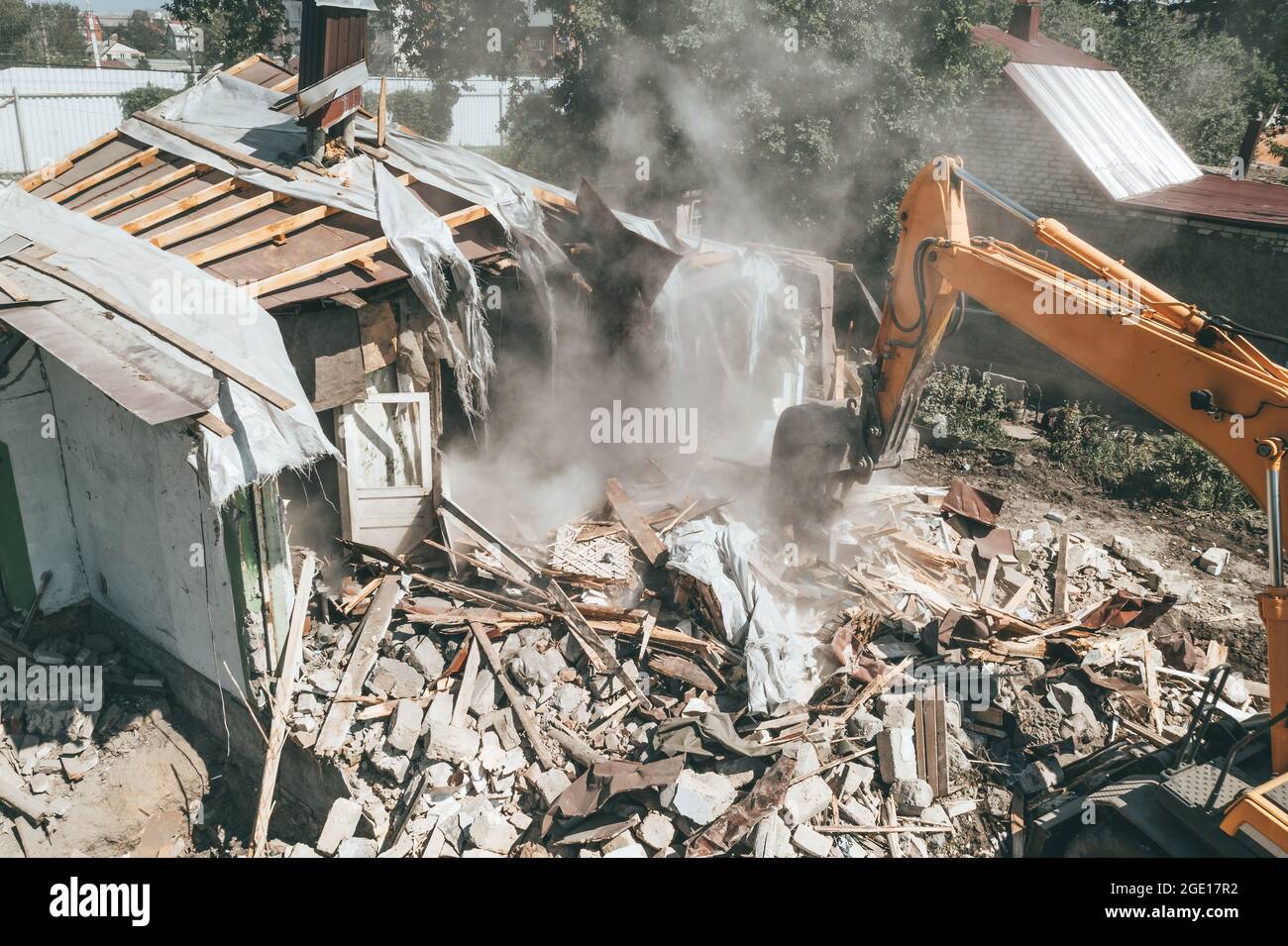 Destruction of old house by excavator. Bucket of excavator breaks ...