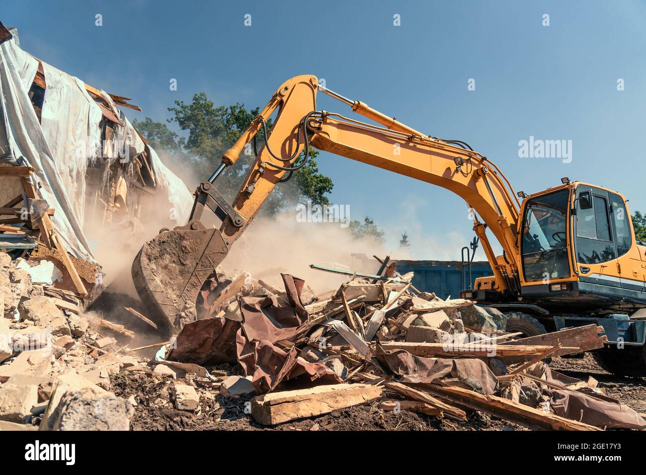 Destruction of old house by excavator with lot of dust. Bucket of ...