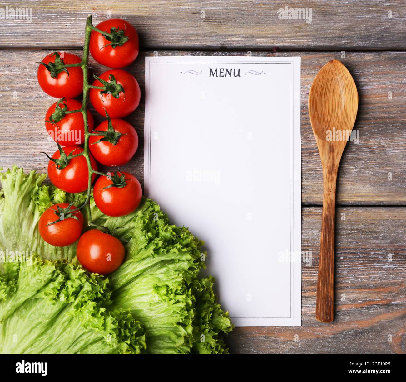Menu sheet of paper with cherry tomatoes and lettuce on rustic wooden ...