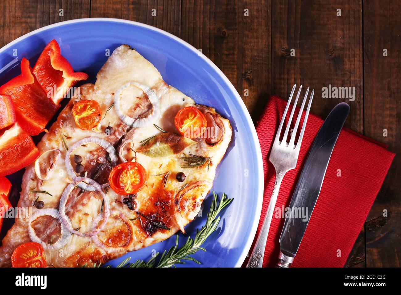 Dish of Pangasius fillet with spices and vegetables on wooden table ...