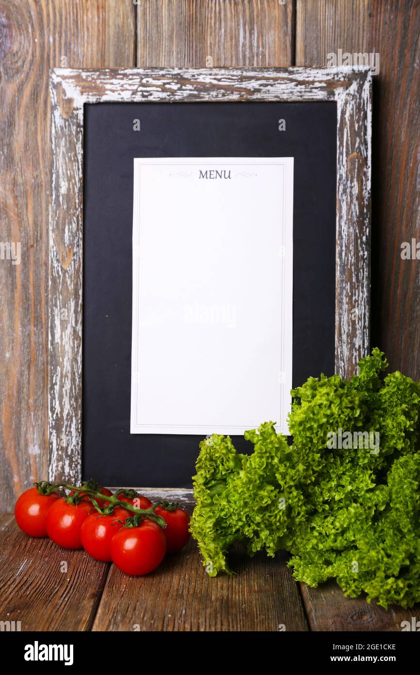 Menu board on rustic wooden planks background with cherry tomatoes and ...