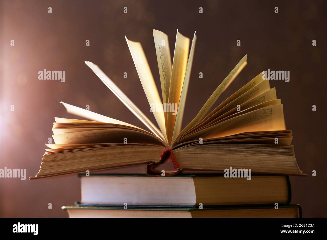 Books with light over dark background Stock Photo - Alamy