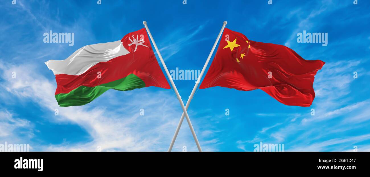 flags of China and Oman waving in the wind on flagpoles against sky ...