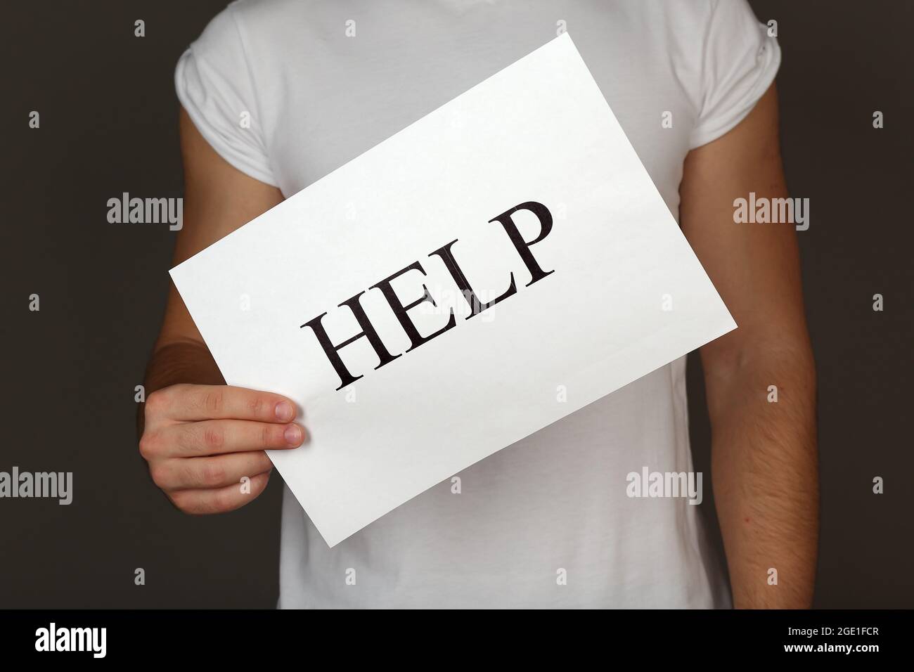 Sheet of paper with Help sign in male hand on dark background Stock ...
