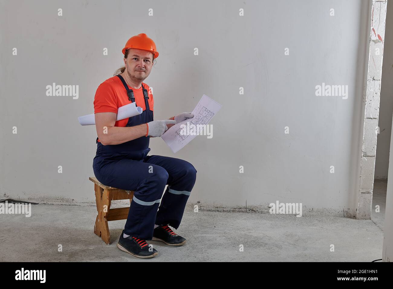 an engineer wearing a helmet looks at the project drawings Stock Photo ...